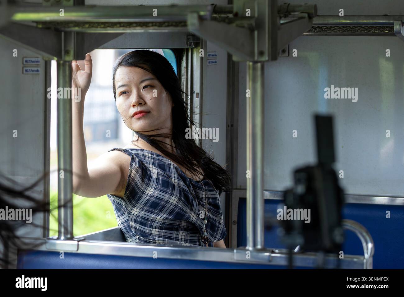 A female Chinese tourist is seen posing by the train window while ...
