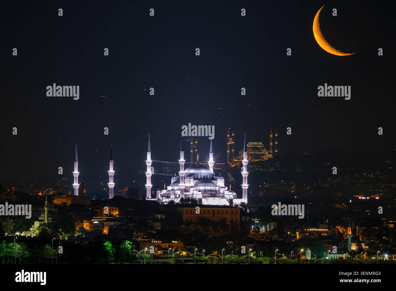 The crescent moon rises behind Sultanahmet mosque, front, and Camlica ...