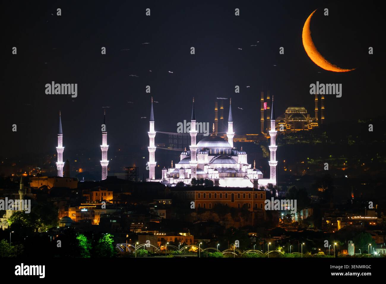 The crescent moon rises behind Sultanahmet mosque, front, and Camlica ...