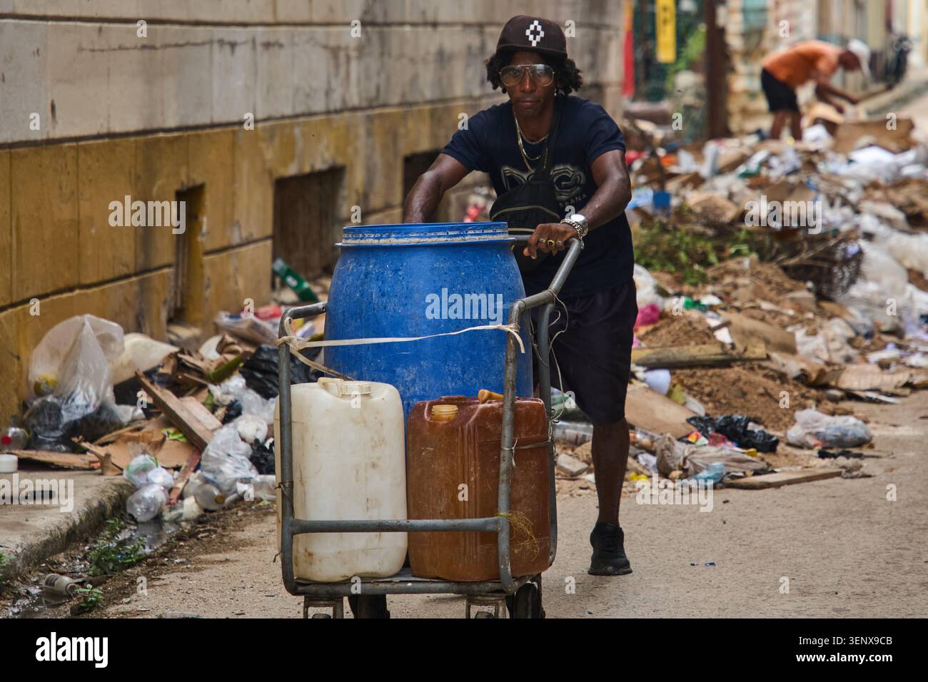 A man pushes a cart of empty containers to fill with water in Havana ...