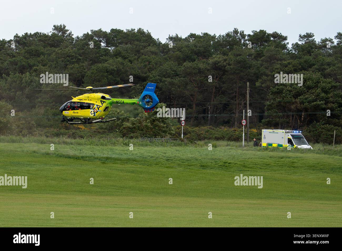 Air Ambulance helicopter hovers near a ground ambulance at Lossiemouth ...