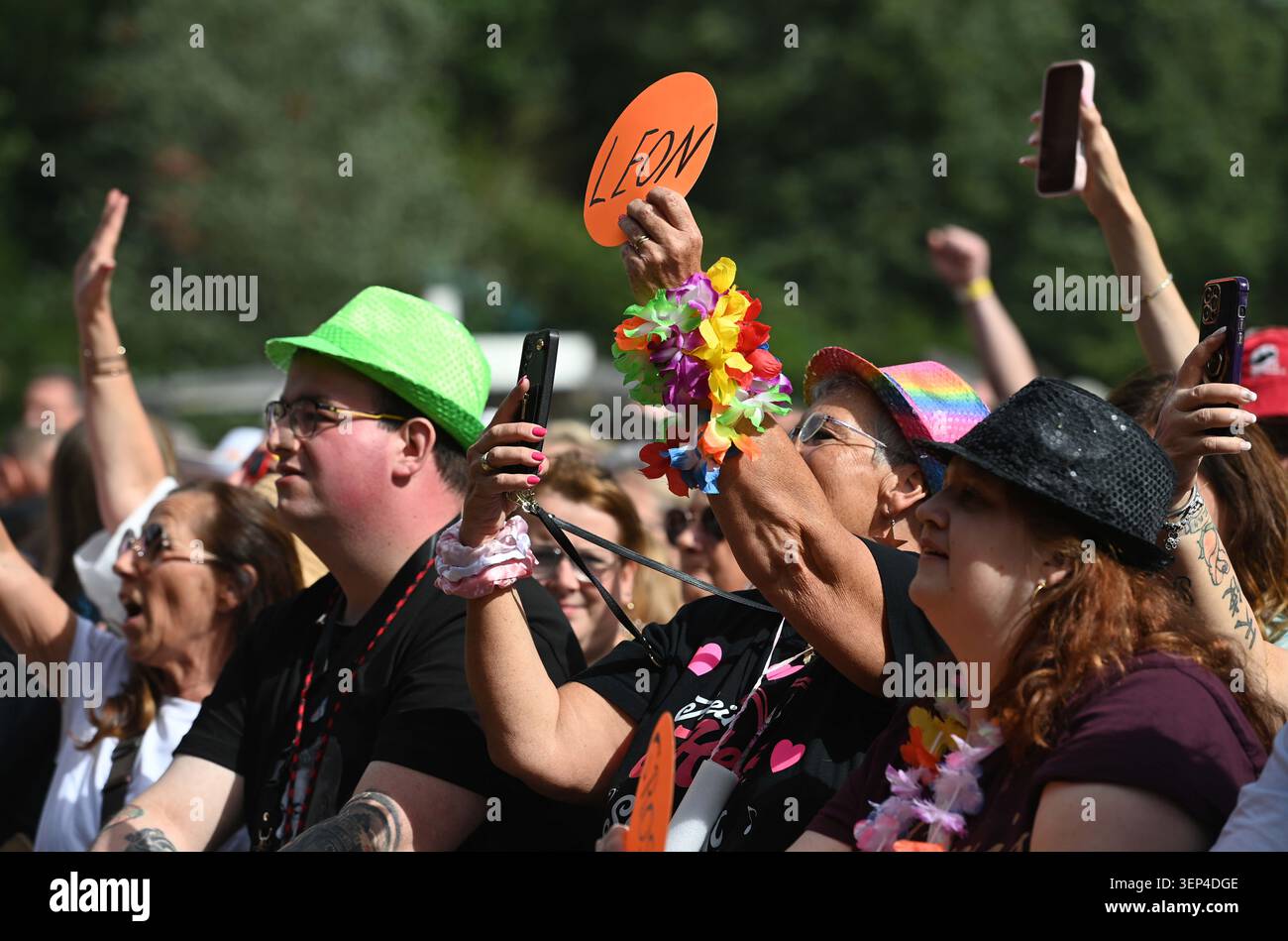 Schlager fans in colorful costumes celebrating at the concert, feature ...