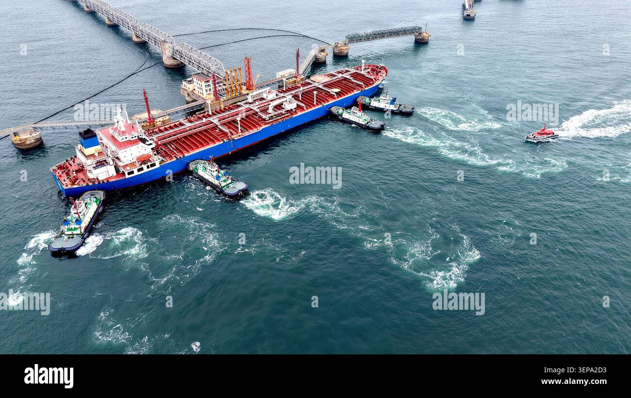 An oil tanker carrying imported crude oil docks at a berth in Qingdao ...