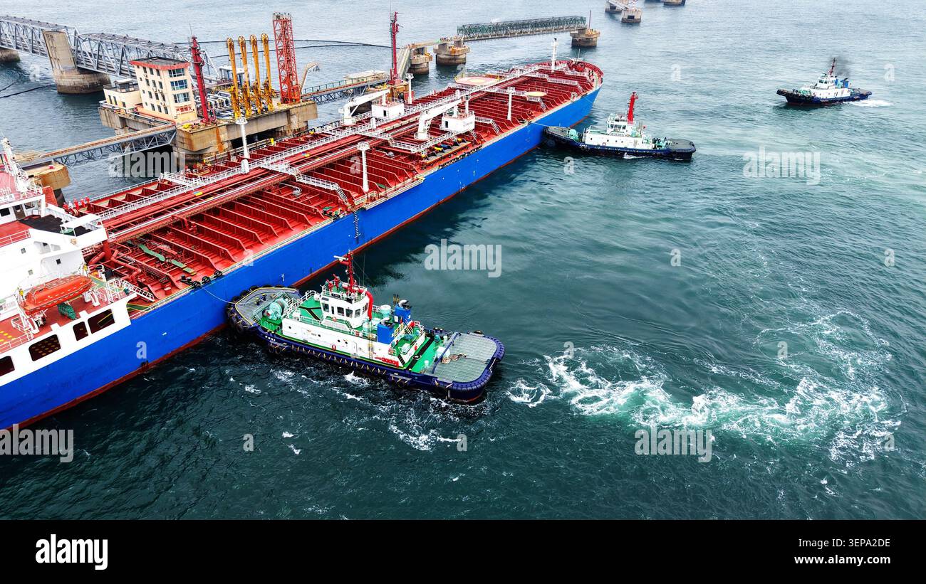 An oil tanker carrying imported crude oil docks at a berth in Qingdao ...