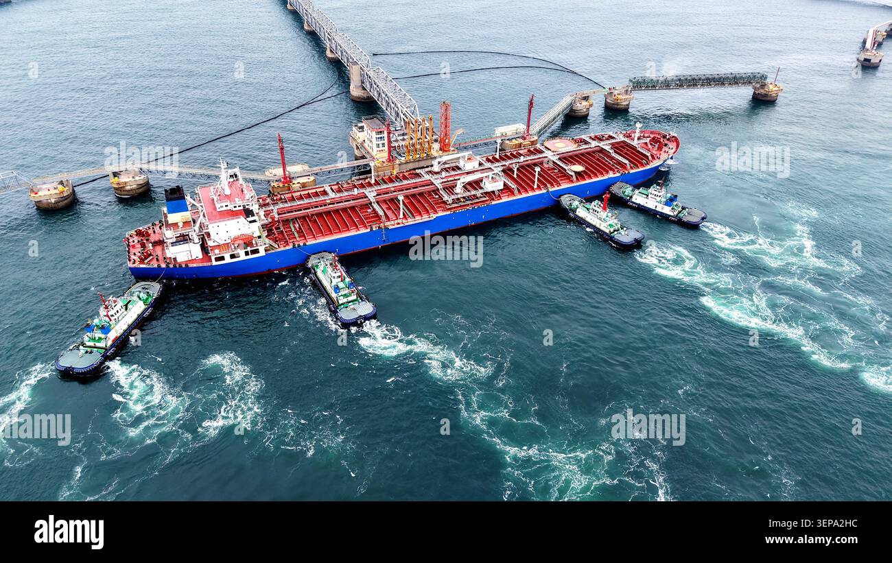 An oil tanker carrying imported crude oil docks at a berth in Qingdao ...