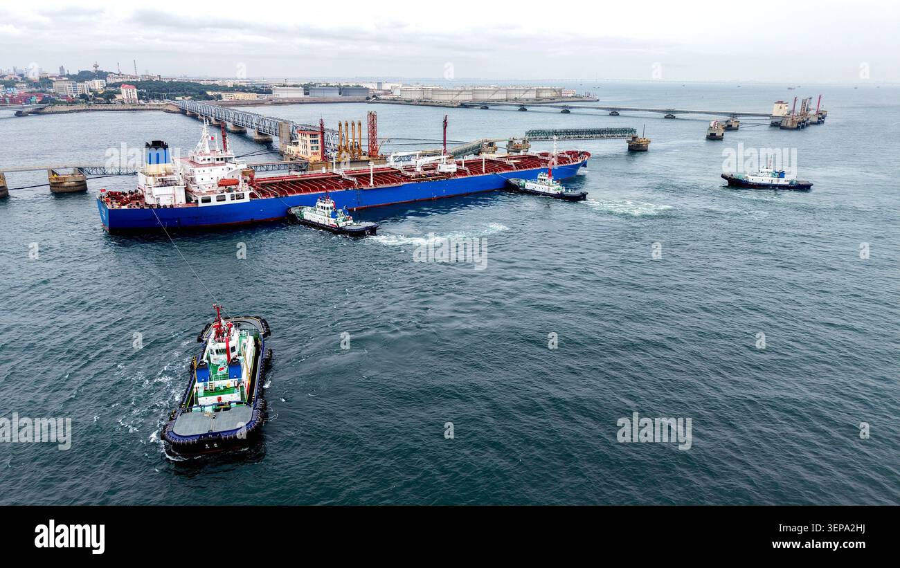 An oil tanker carrying imported crude oil docks at a berth in Qingdao ...