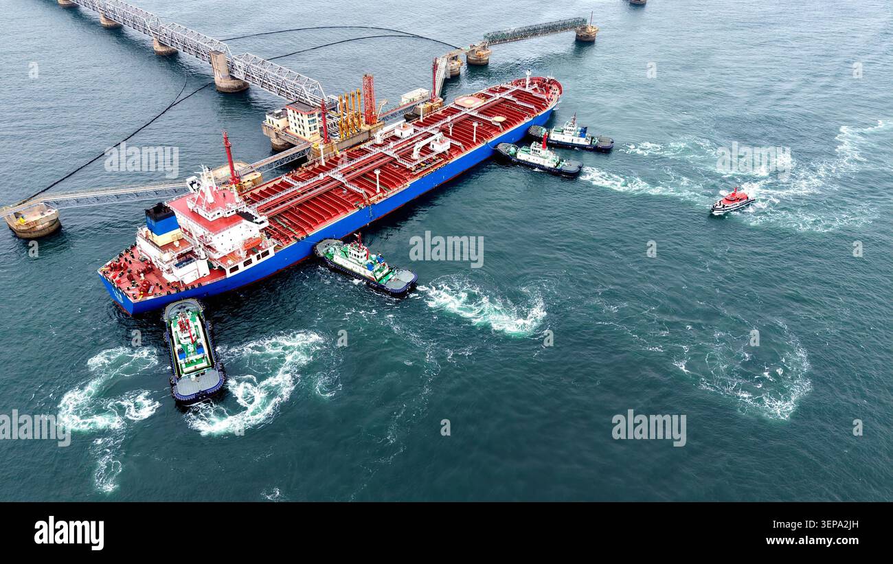 An oil tanker carrying imported crude oil docks at a berth in Qingdao ...