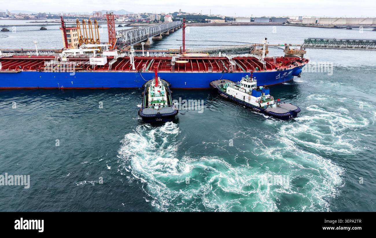 An oil tanker carrying imported crude oil docks at a berth in Qingdao ...