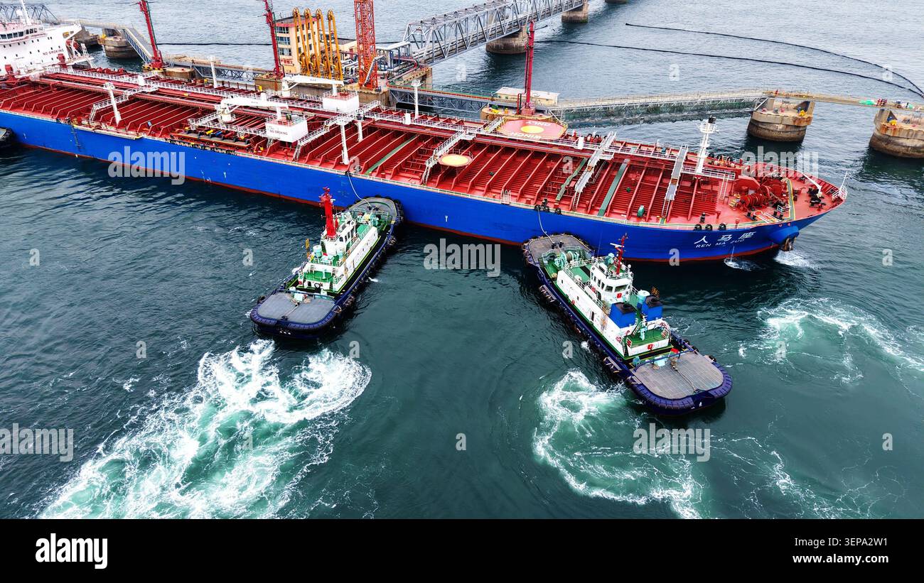 An oil tanker carrying imported crude oil docks at a berth in Qingdao ...