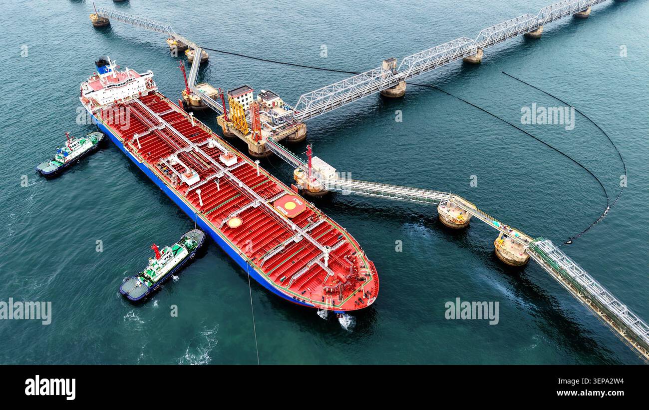 An oil tanker carrying imported crude oil docks at a berth in Qingdao ...
