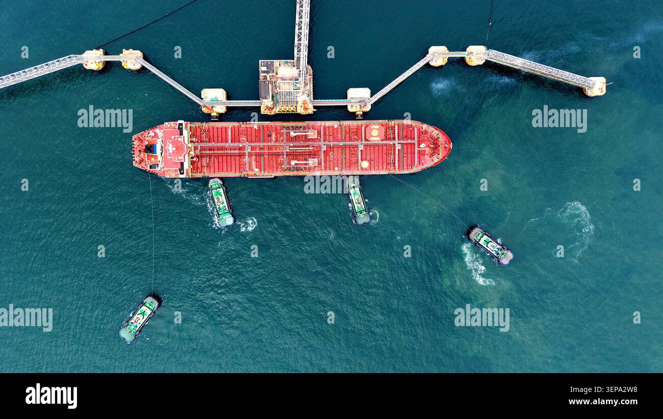 An oil tanker carrying imported crude oil docks at a berth in Qingdao ...