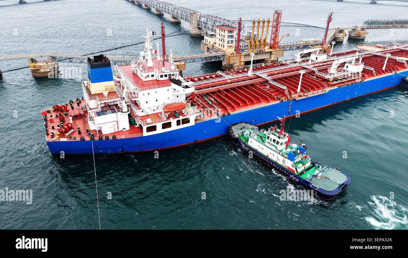 An oil tanker carrying imported crude oil docks at a berth in Qingdao ...