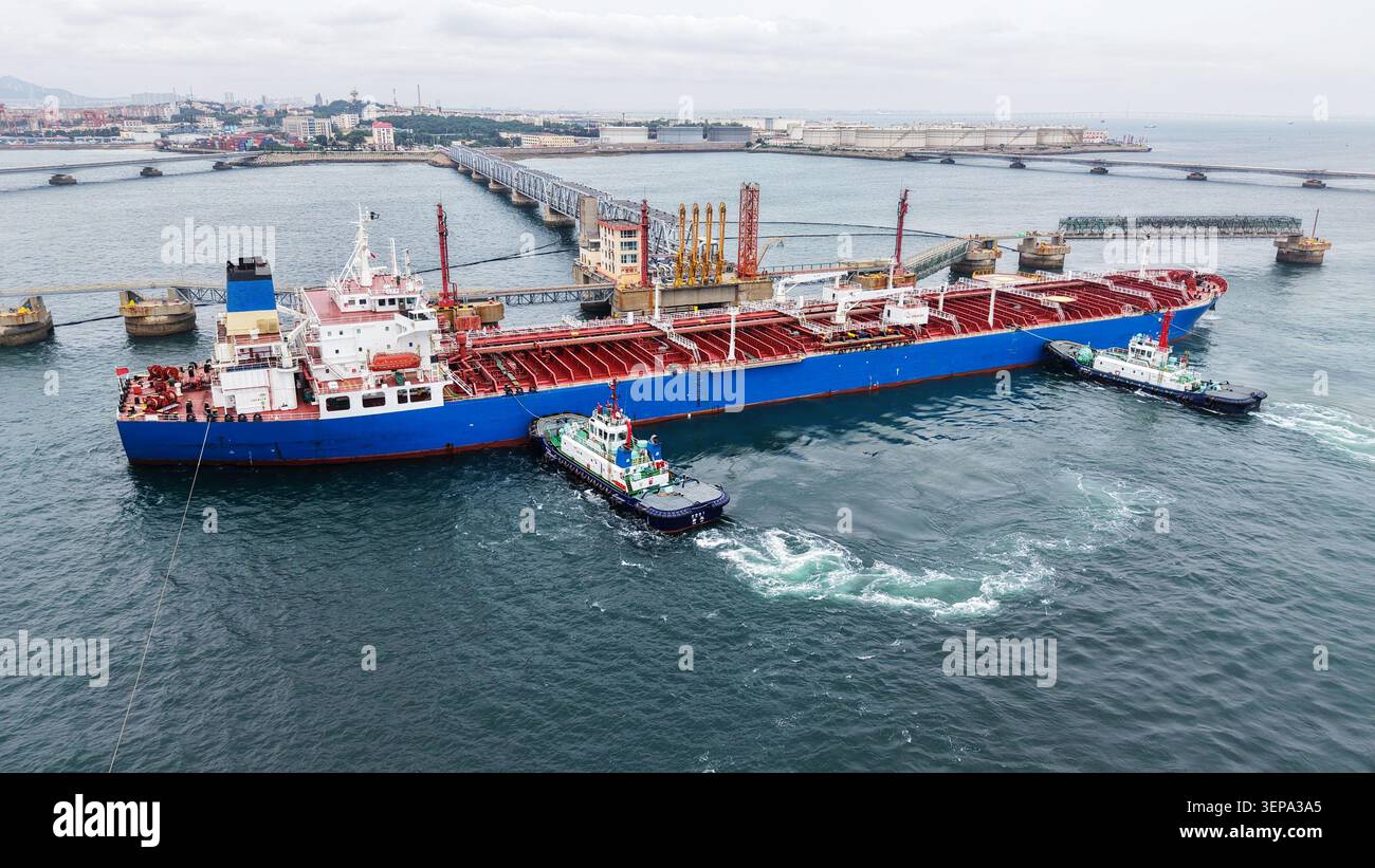 An oil tanker carrying imported crude oil docks at a berth in Qingdao ...
