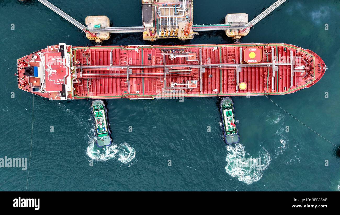 An oil tanker carrying imported crude oil docks at a berth in Qingdao ...