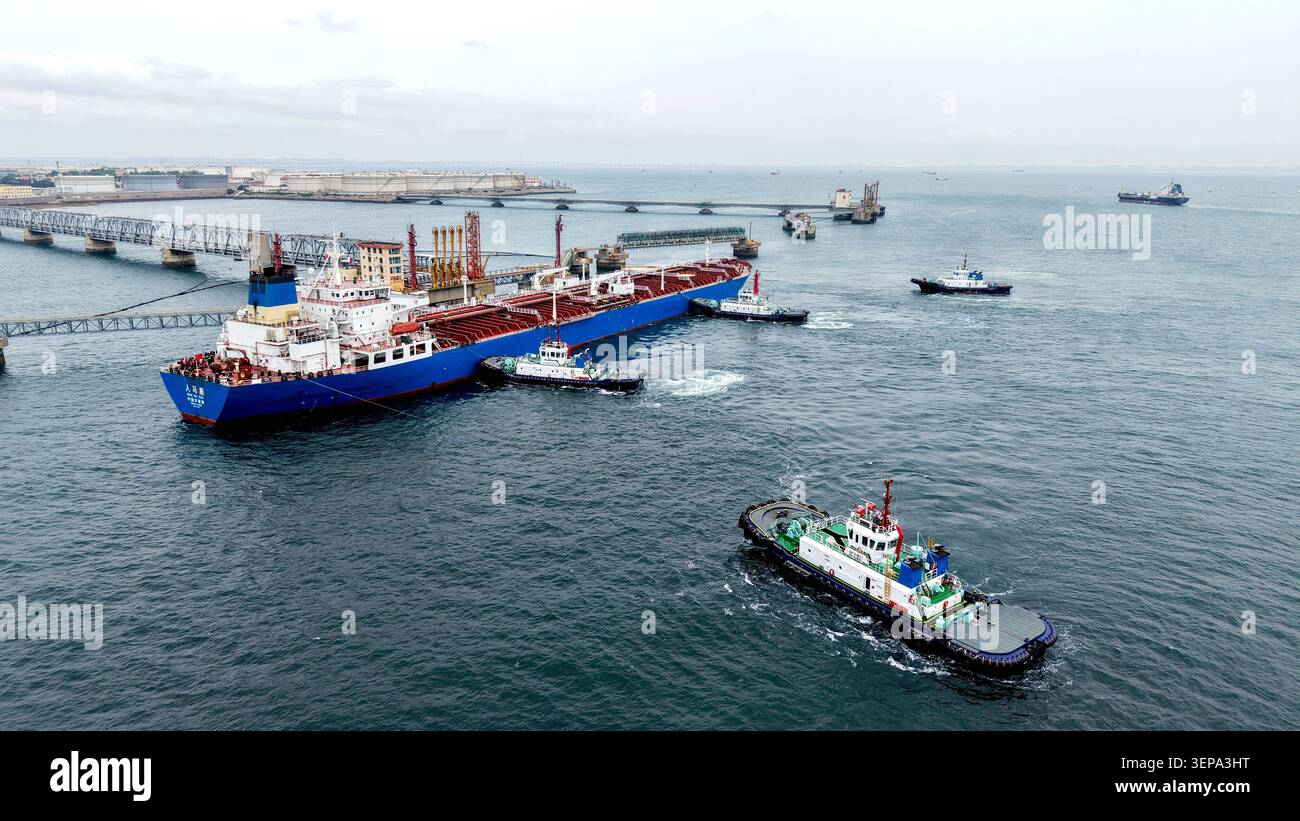 An oil tanker carrying imported crude oil docks at a berth in Qingdao ...