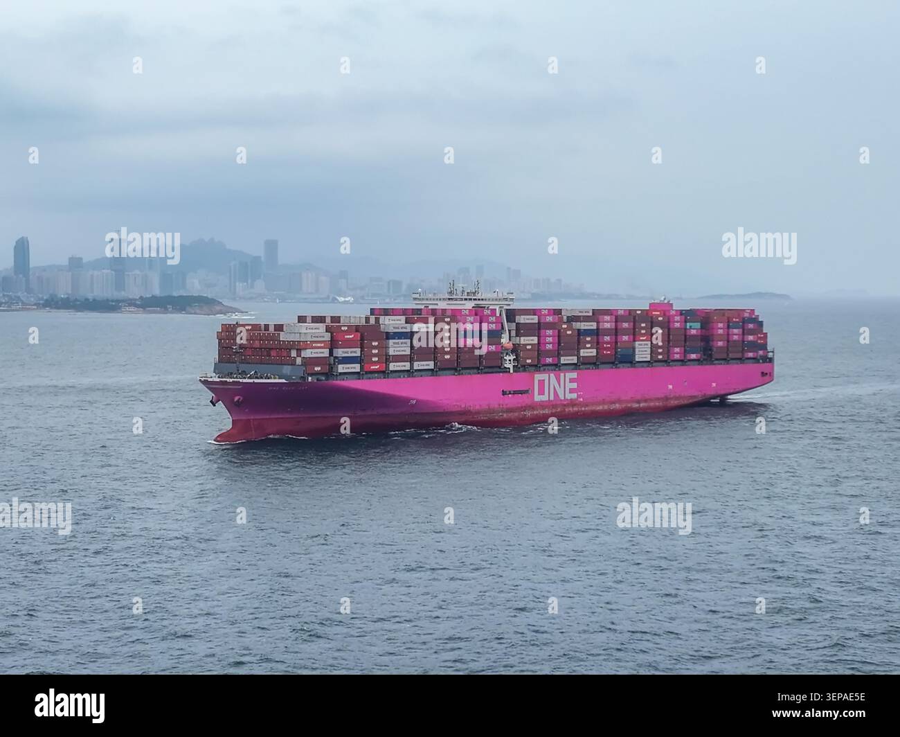 A large ONE container ship and an HMM cargo ship navigate Qingdao Port ...