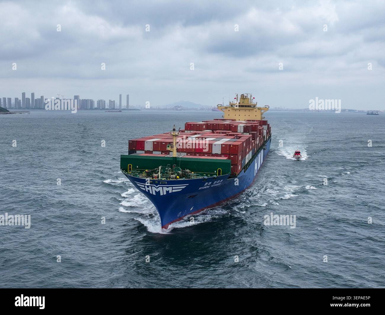 A large ONE container ship and an HMM cargo ship navigate Qingdao Port ...