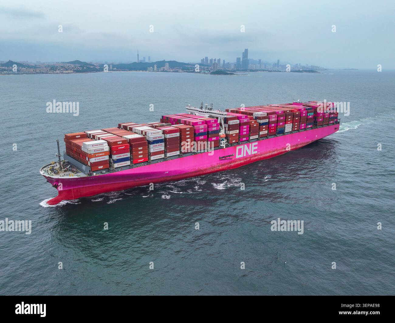 A large ONE container ship and an HMM cargo ship navigate Qingdao Port ...