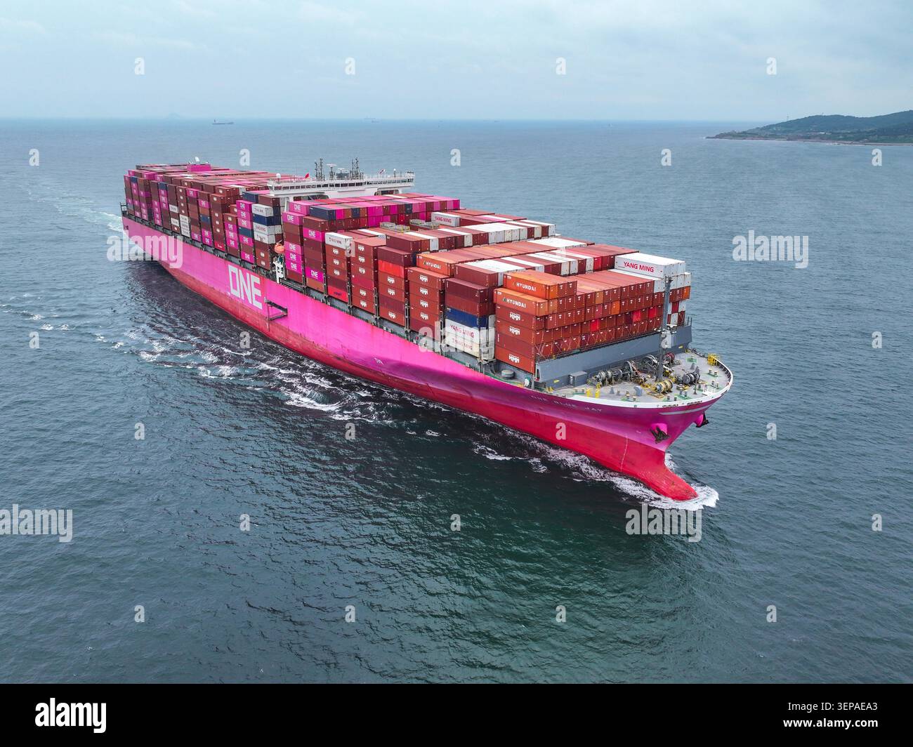 A large ONE container ship and an HMM cargo ship navigate Qingdao Port ...