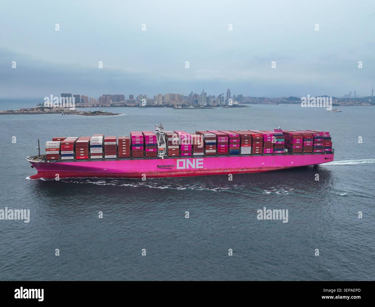 A large ONE container ship and an HMM cargo ship navigate Qingdao Port ...
