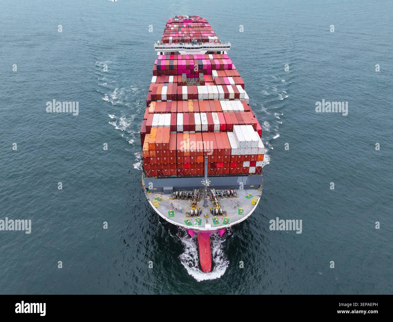 A large ONE container ship and an HMM cargo ship navigate Qingdao Port ...