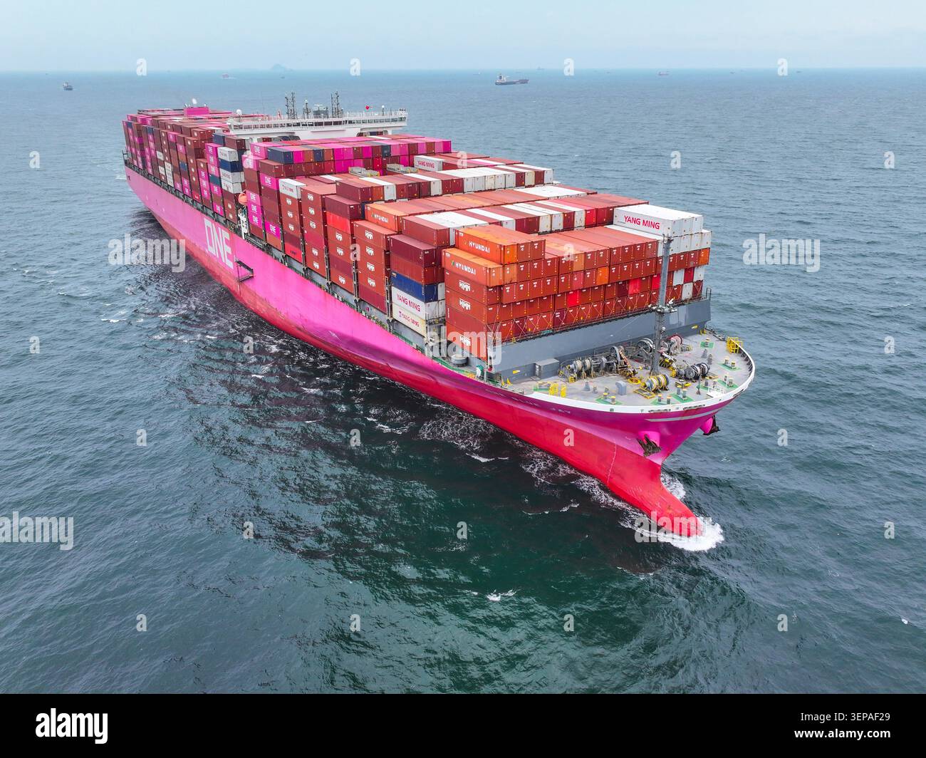 A large ONE container ship and an HMM cargo ship navigate Qingdao Port ...
