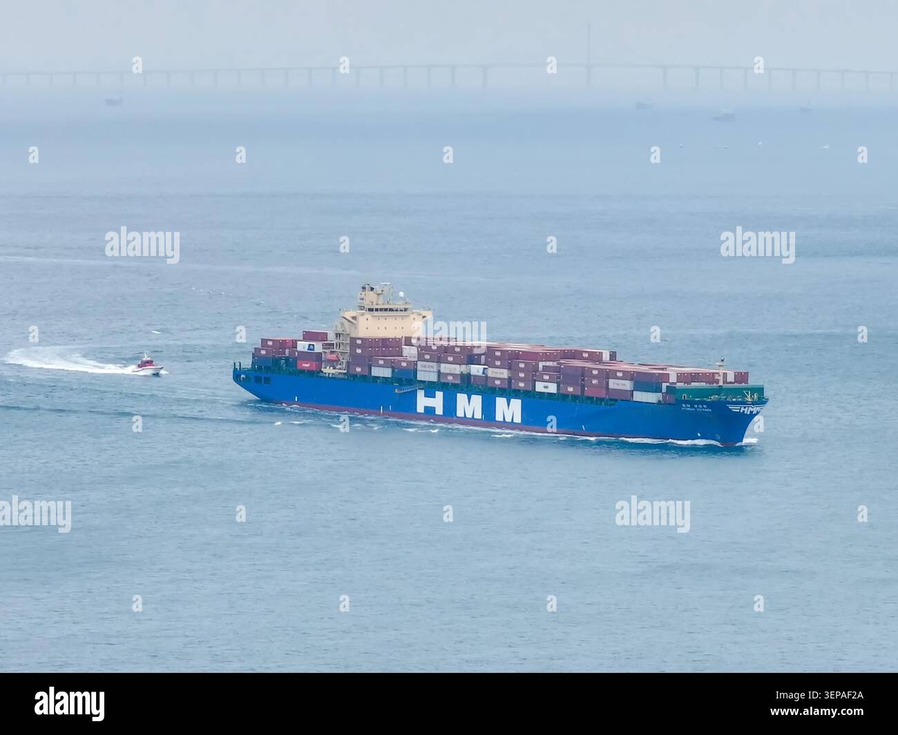 A large ONE container ship and an HMM cargo ship navigate Qingdao Port ...
