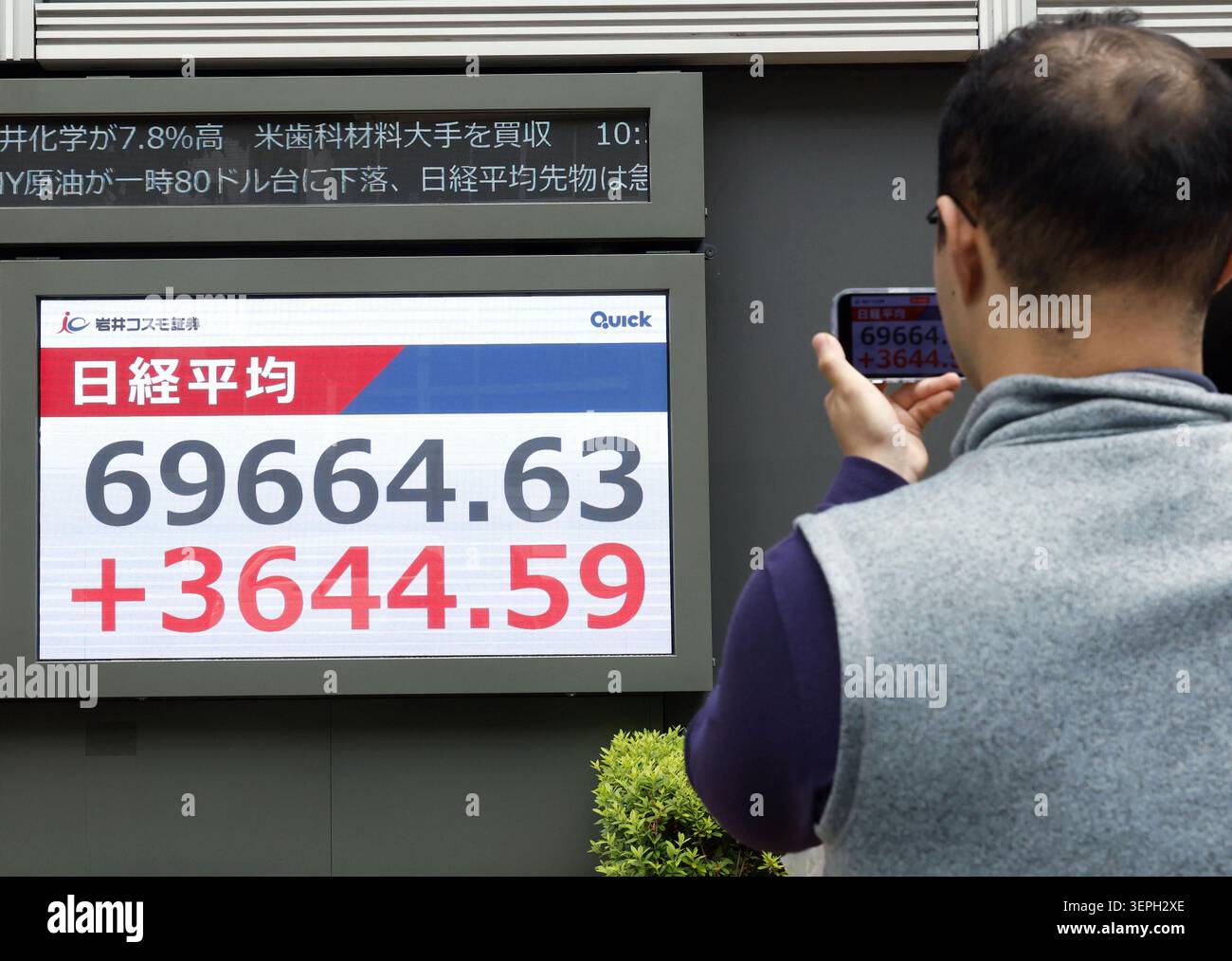 A person films an electronic stock board in Tokyo Monday, June 15, 2026 ...