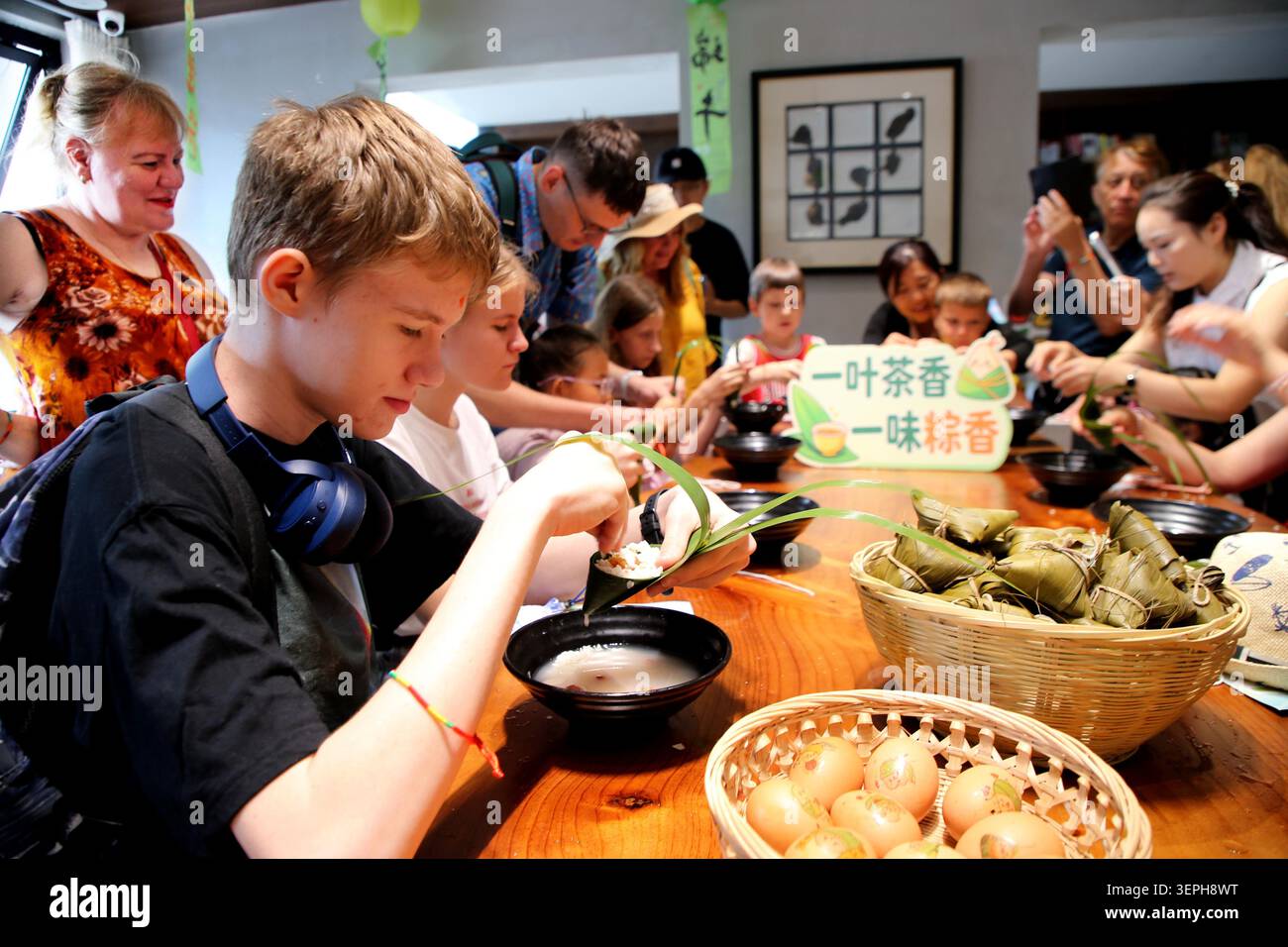 Chinese and foreign children make zongzi during a Dragon Boat Festival ...