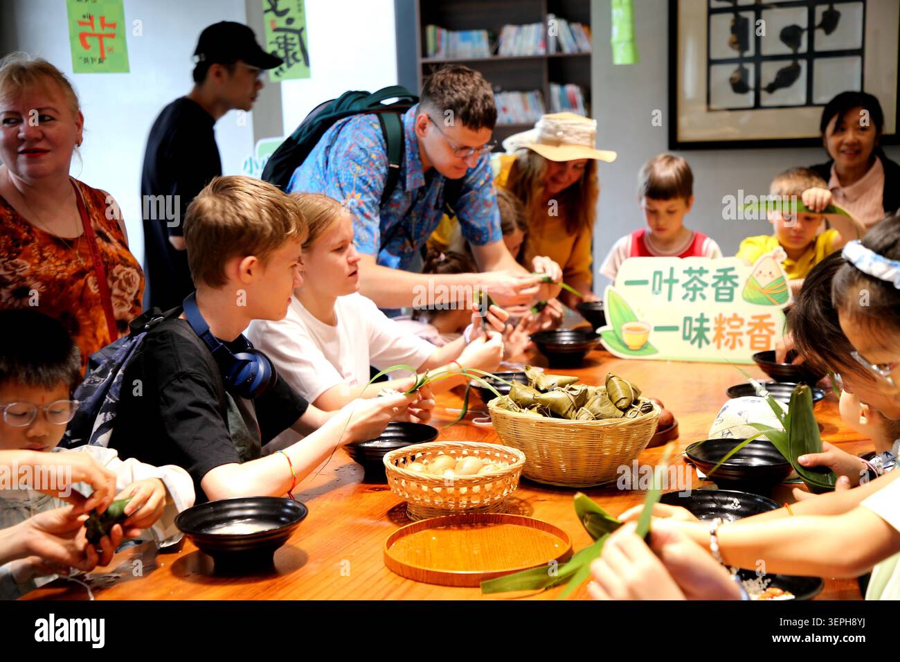 Chinese and foreign children make zongzi during a Dragon Boat Festival ...