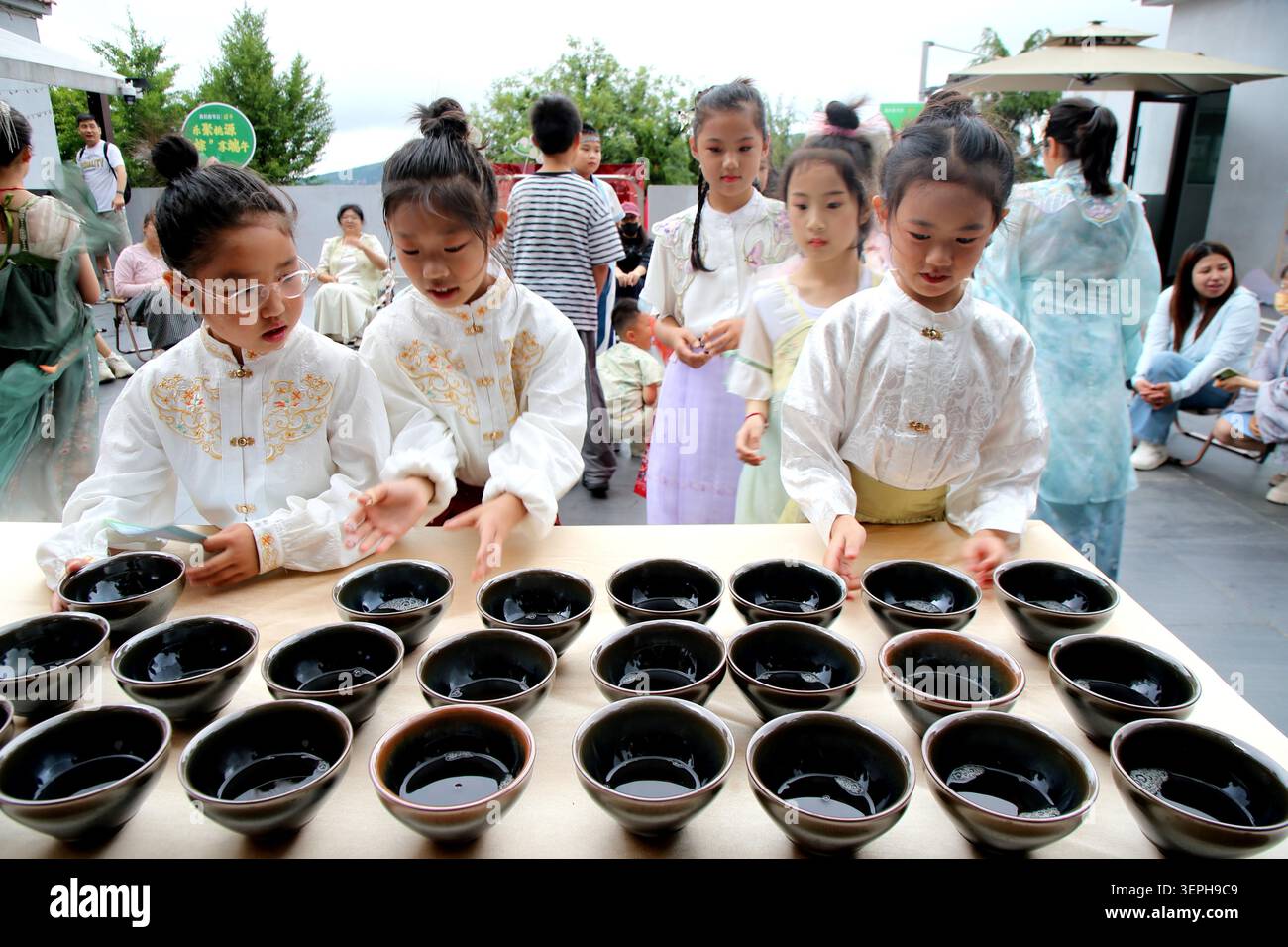 Children serve tea to elders during a Dragon Boat Festival event in ...