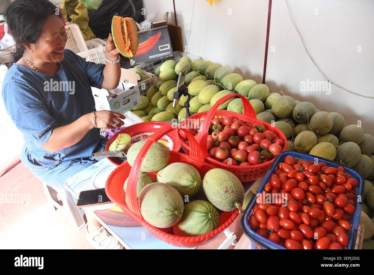 A farmer sells fruits via livestreaming at a vegetable and fruit ...