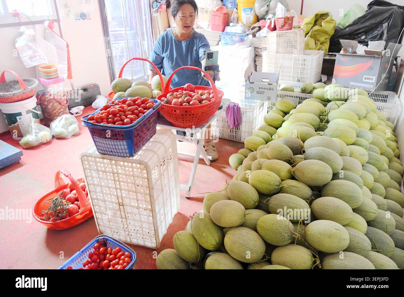 A farmer sells fruits via livestreaming at a vegetable and fruit ...