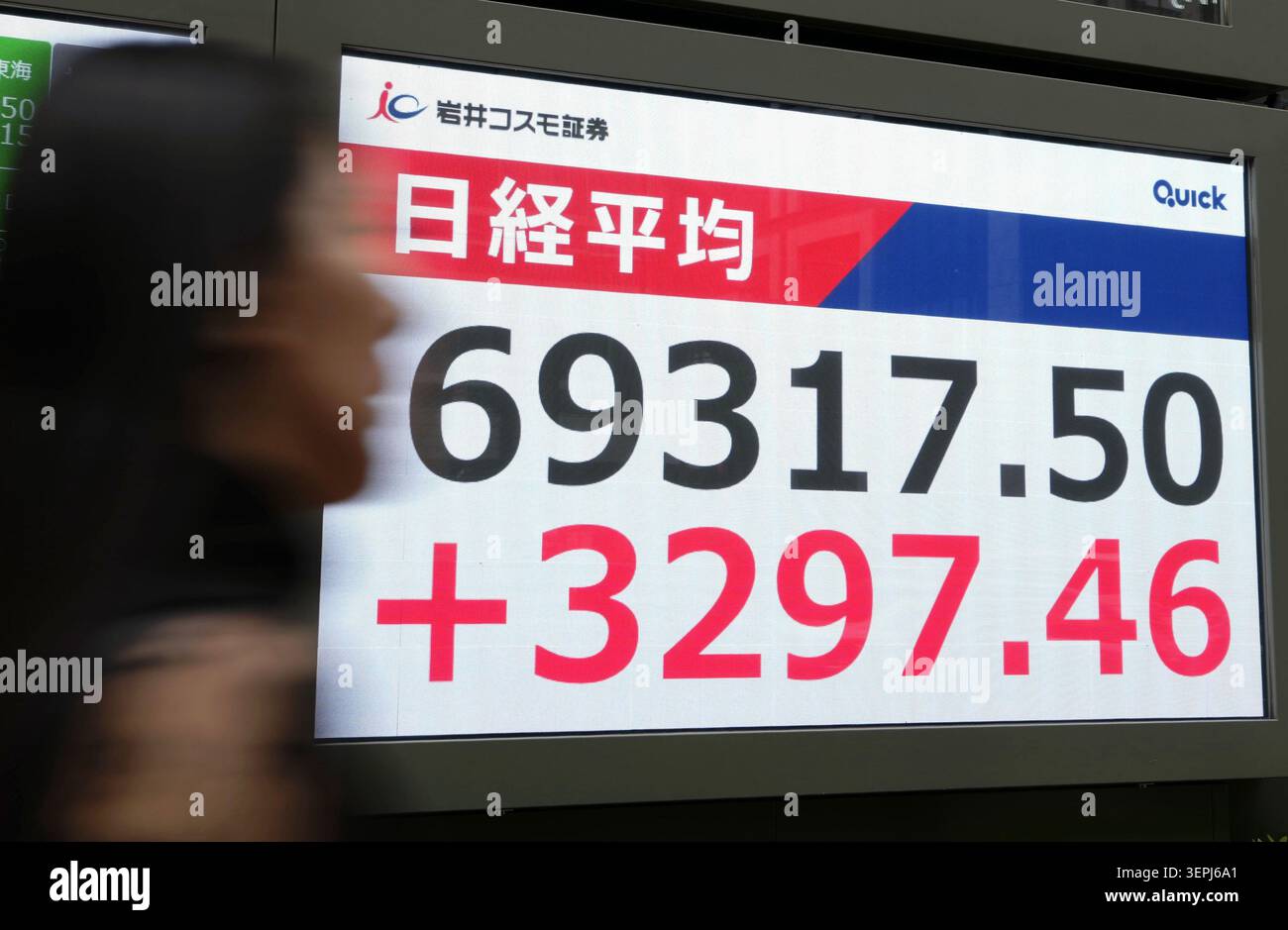 A person walks past an electronic stock board in Tokyo Monday, June 15 ...