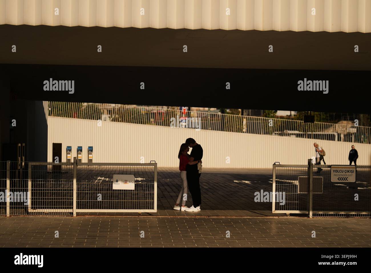 A couple kiss at Kabatas ferry terminal as the sun rises in Istanbul ...