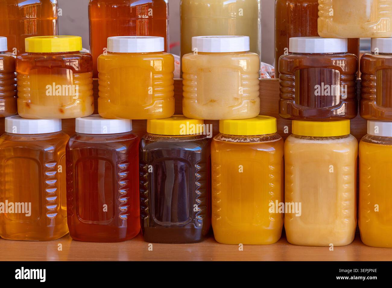 Jars of various honeys on wooden shelves. Ginger honey, sea buckthorn ...