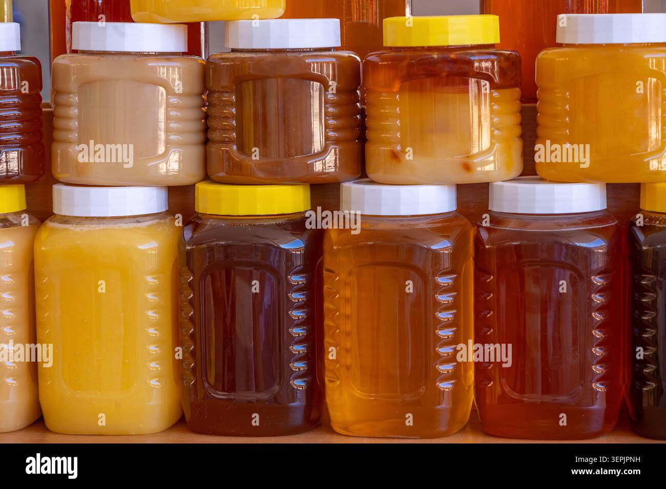 Jars of various honeys on wooden shelves. Ginger honey, sea buckthorn ...