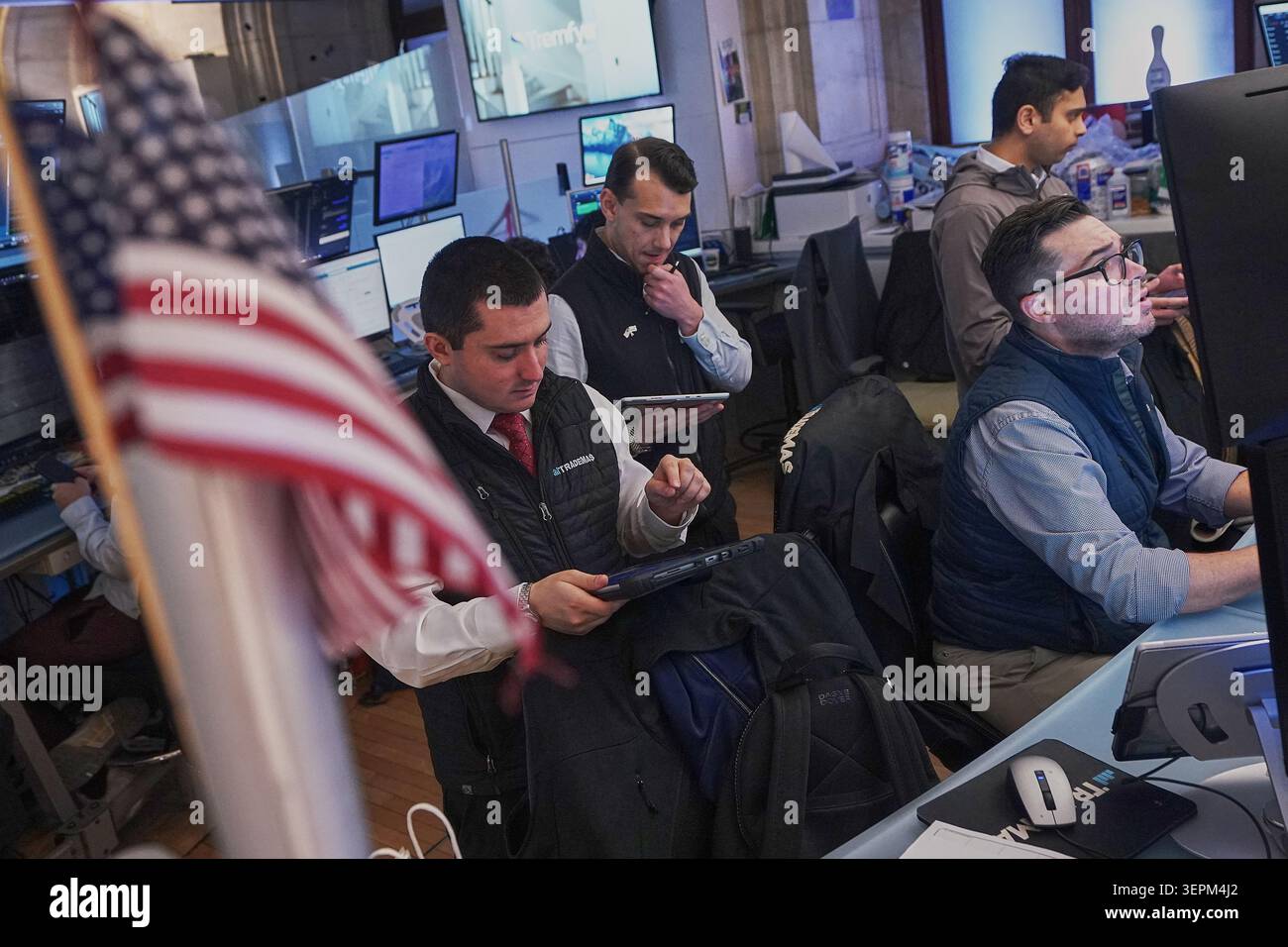 Joseph Lawler, seated right, works with colleagues on the floor of the ...