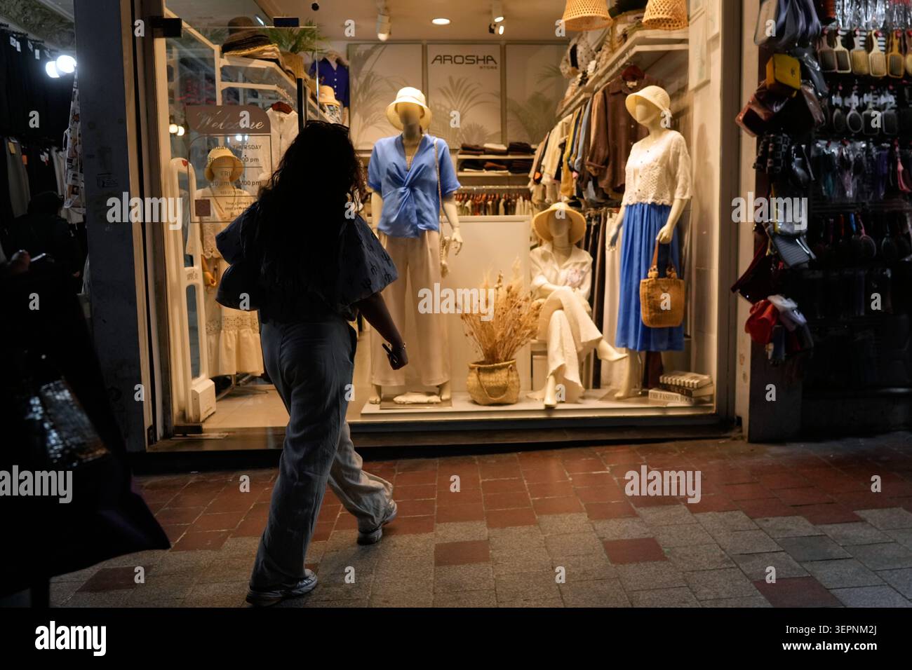 A woman looks at the window of a women's cloths shop in northern Tehran ...