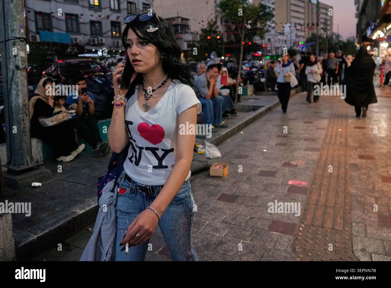 A woman walks along a sidewalk at Tajrish square in northern Tehran ...