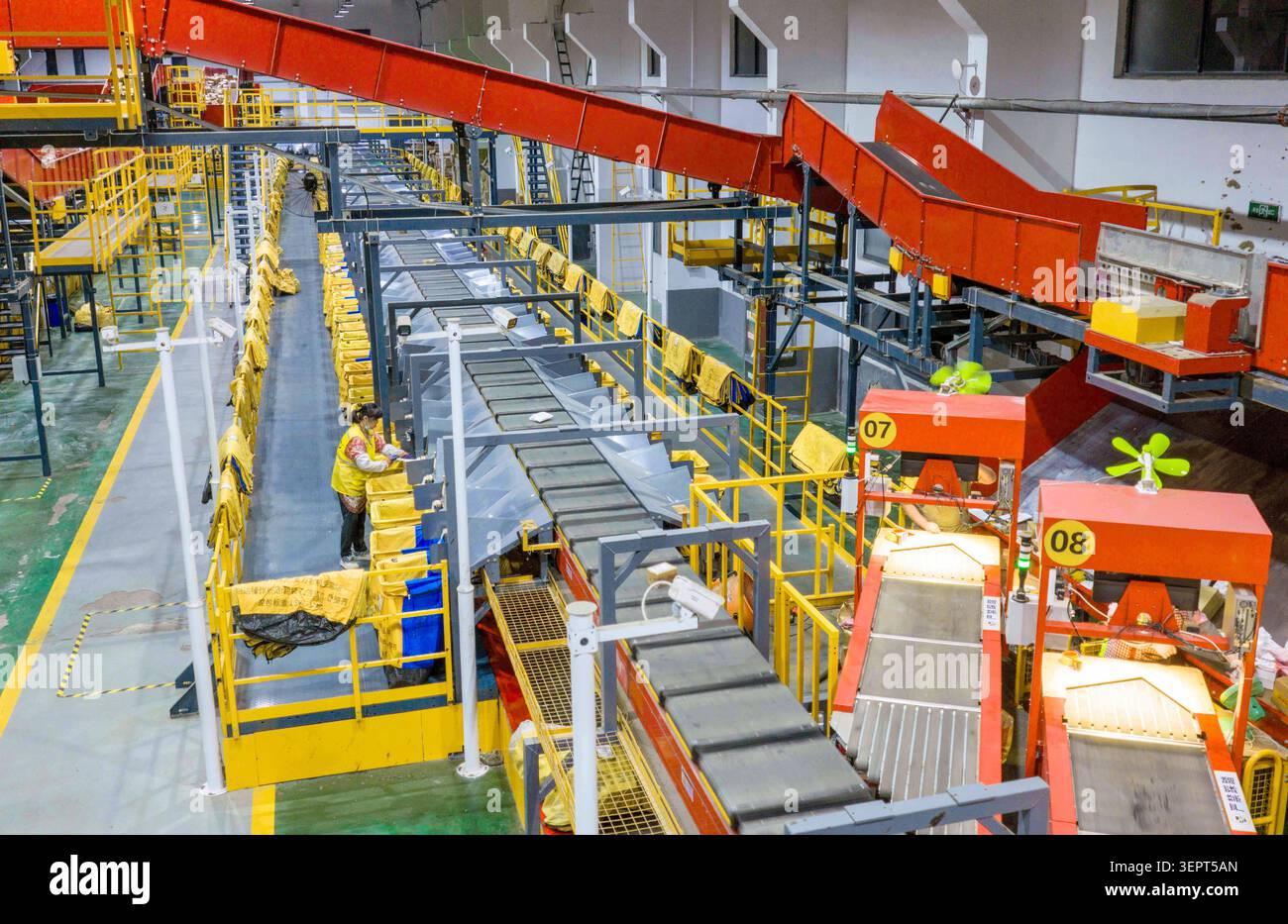 Workers sort packages on an intelligent conveyor belt at a Yunda ...