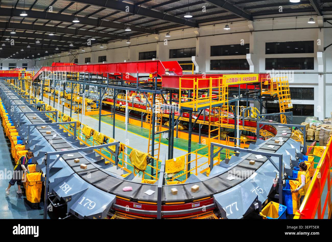 Workers sort packages on an intelligent conveyor belt at a Yunda ...