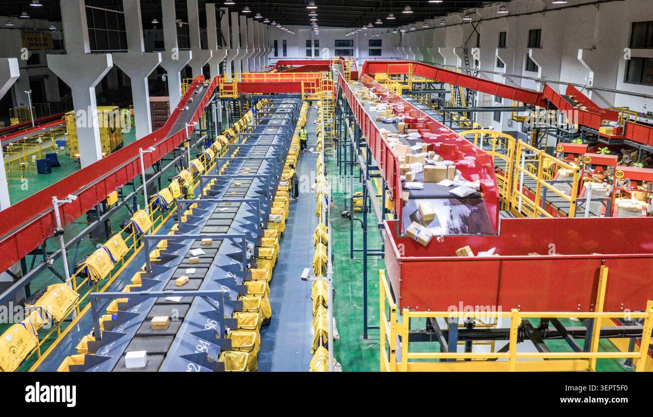 Workers sort packages on an intelligent conveyor belt at a Yunda ...