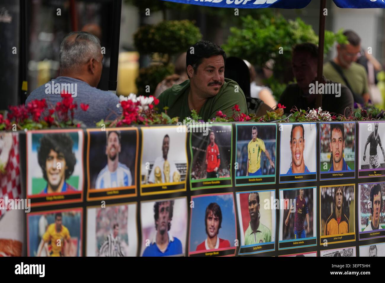 People sit among signage celebrating the World Cup soccer tournament ...