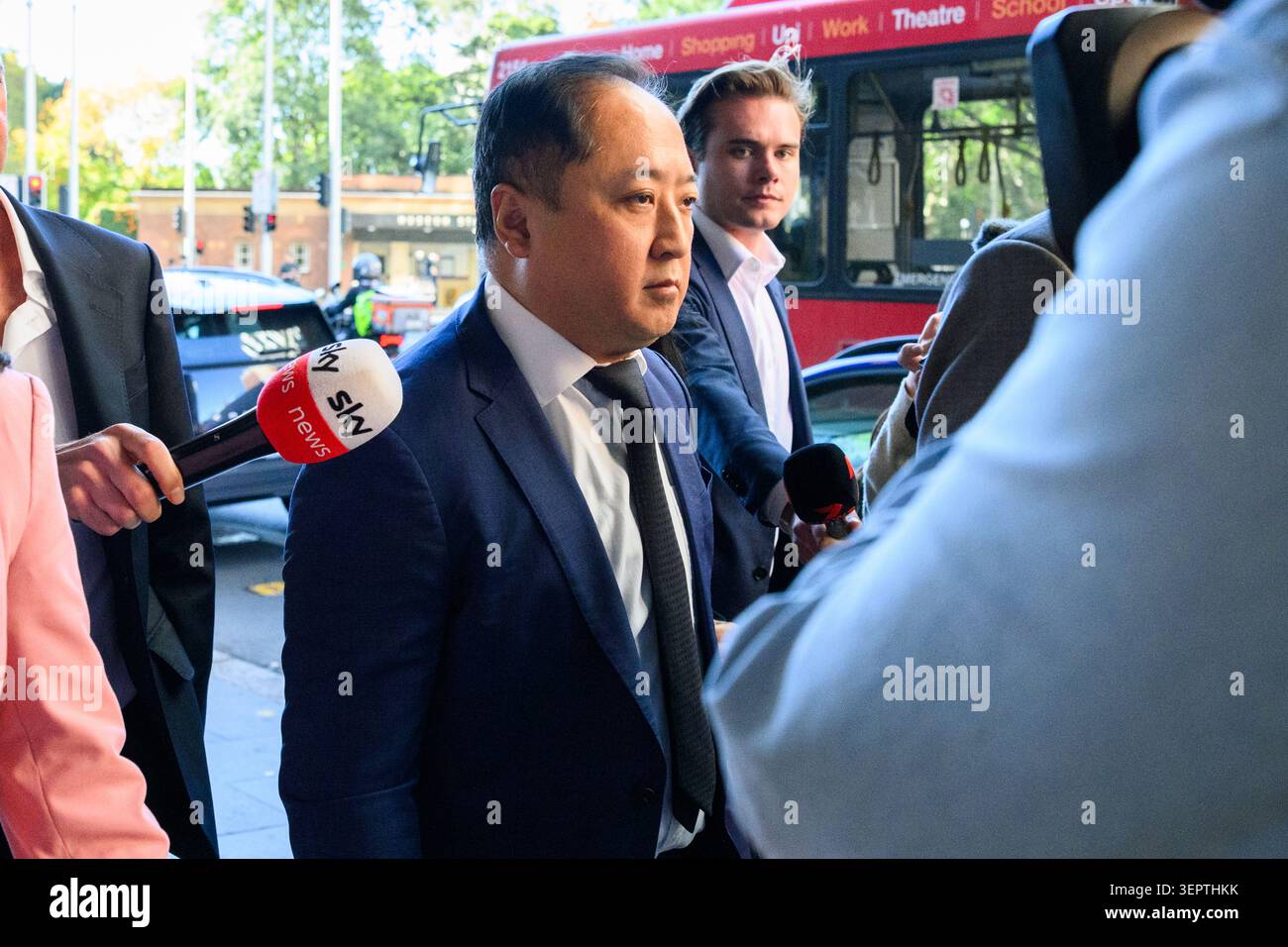 Jonathan Yee (centre) departs the Downing Centre Court, in Sydney ...
