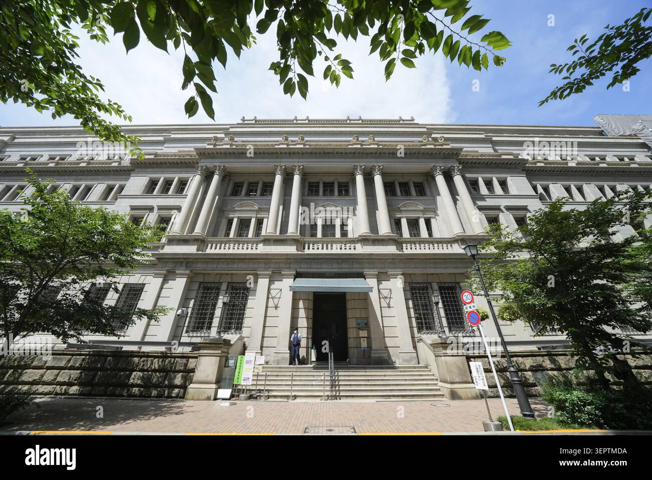 A security guard stands at the entrance of the Bank of Japan ...