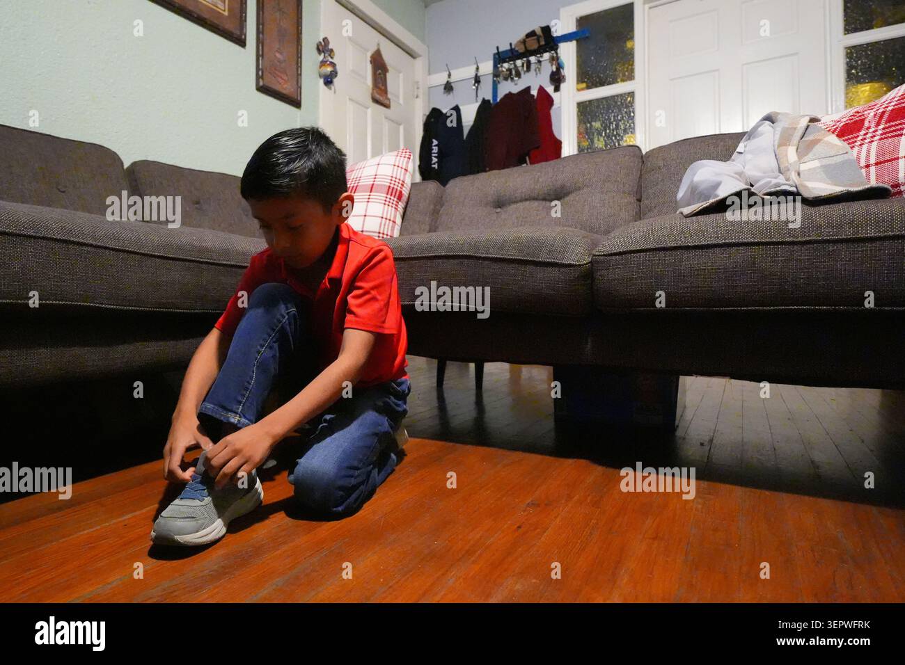 Ian Contreras puts on his shoes before heading off to school Thursday ...