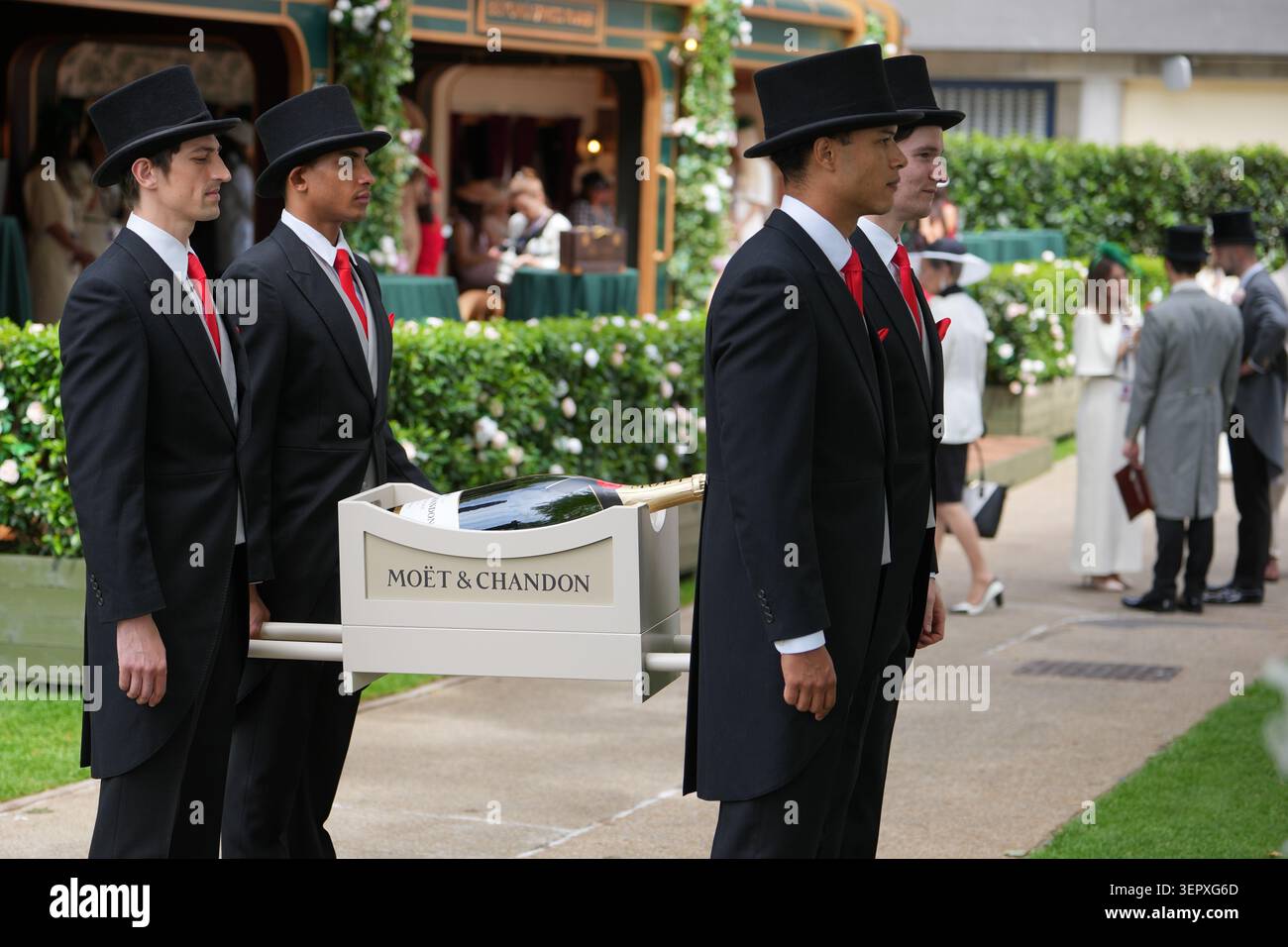 A bootle of Champagne is delivered by waiters during the Royal Ascot ...