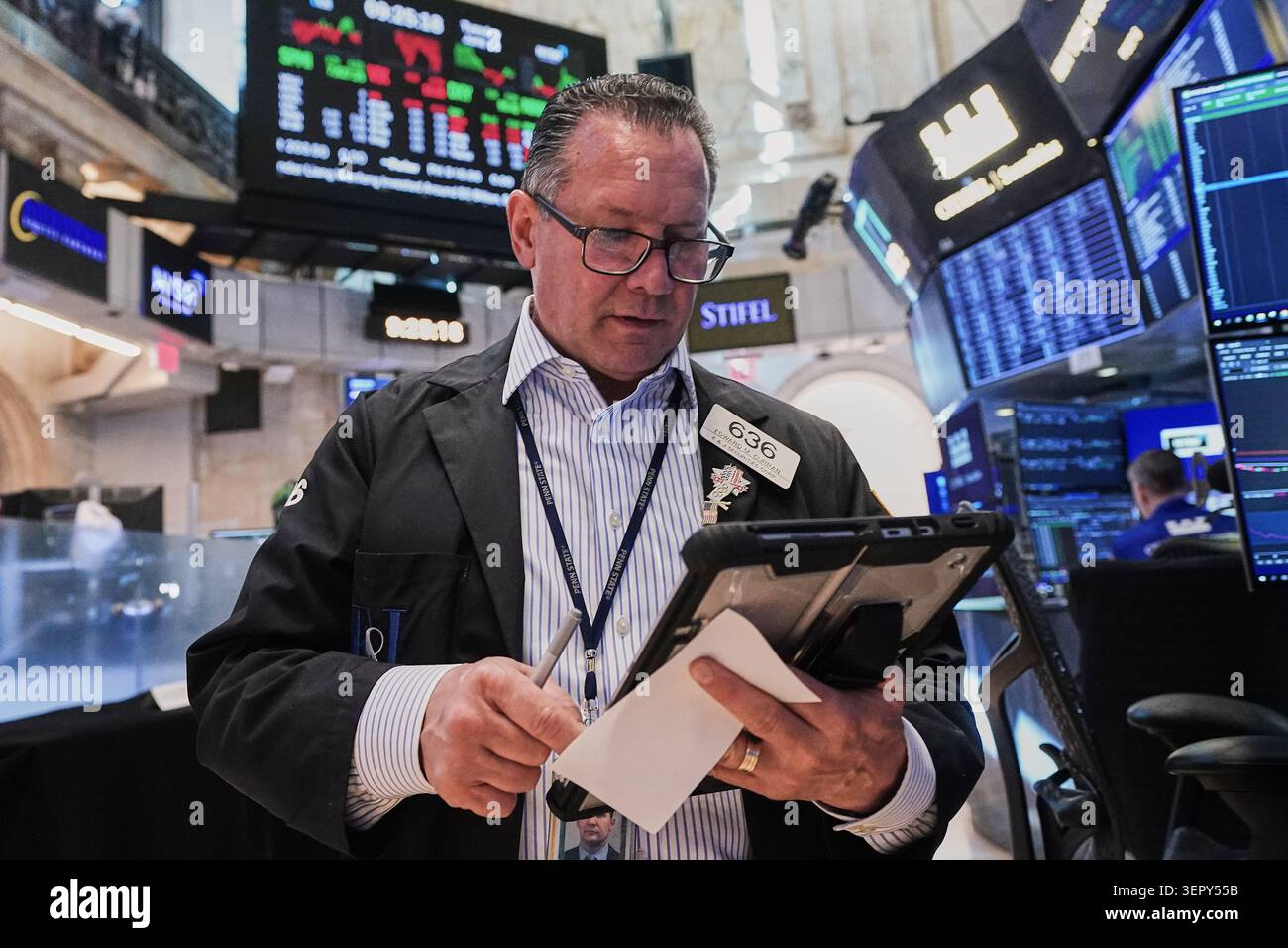 Trader Edward Curran works on the floor of the New York Stock Exchange ...