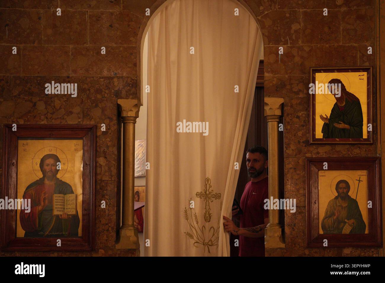 A church caretaker opens a curtain inside St. George Greek Orthodox ...